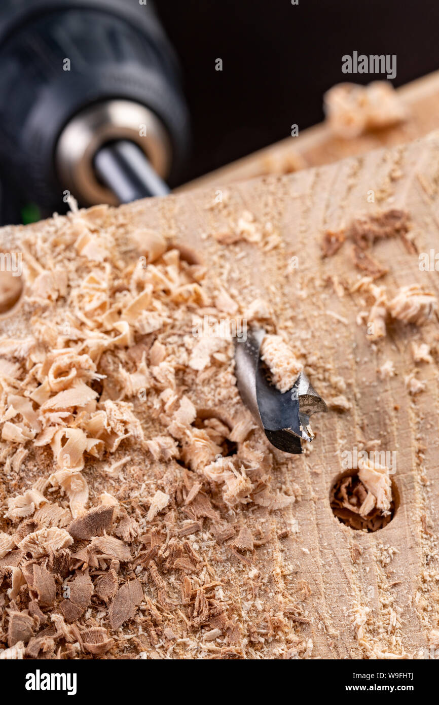 Drilling holes in raw wood. Carpentry drill in a carpentry workshop ...