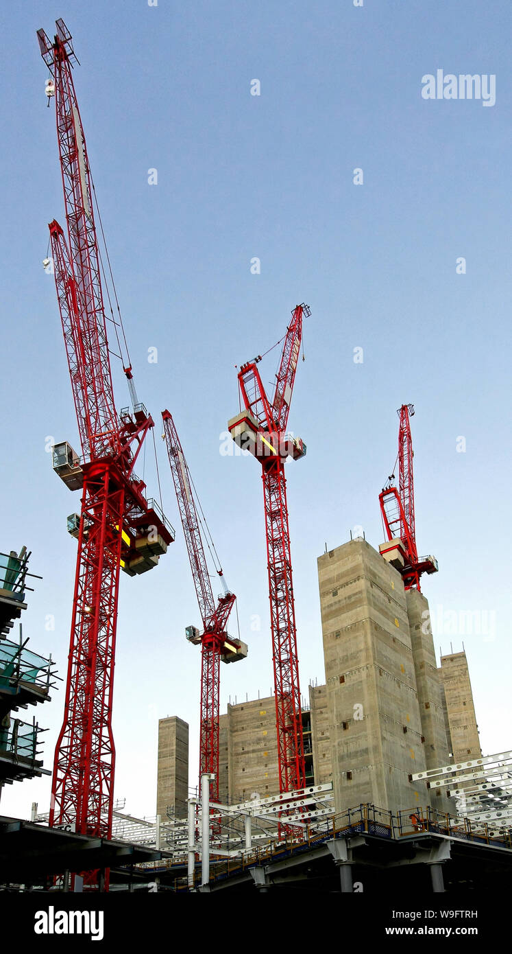 Tall red cranes at big construction site Stock Photo - Alamy
