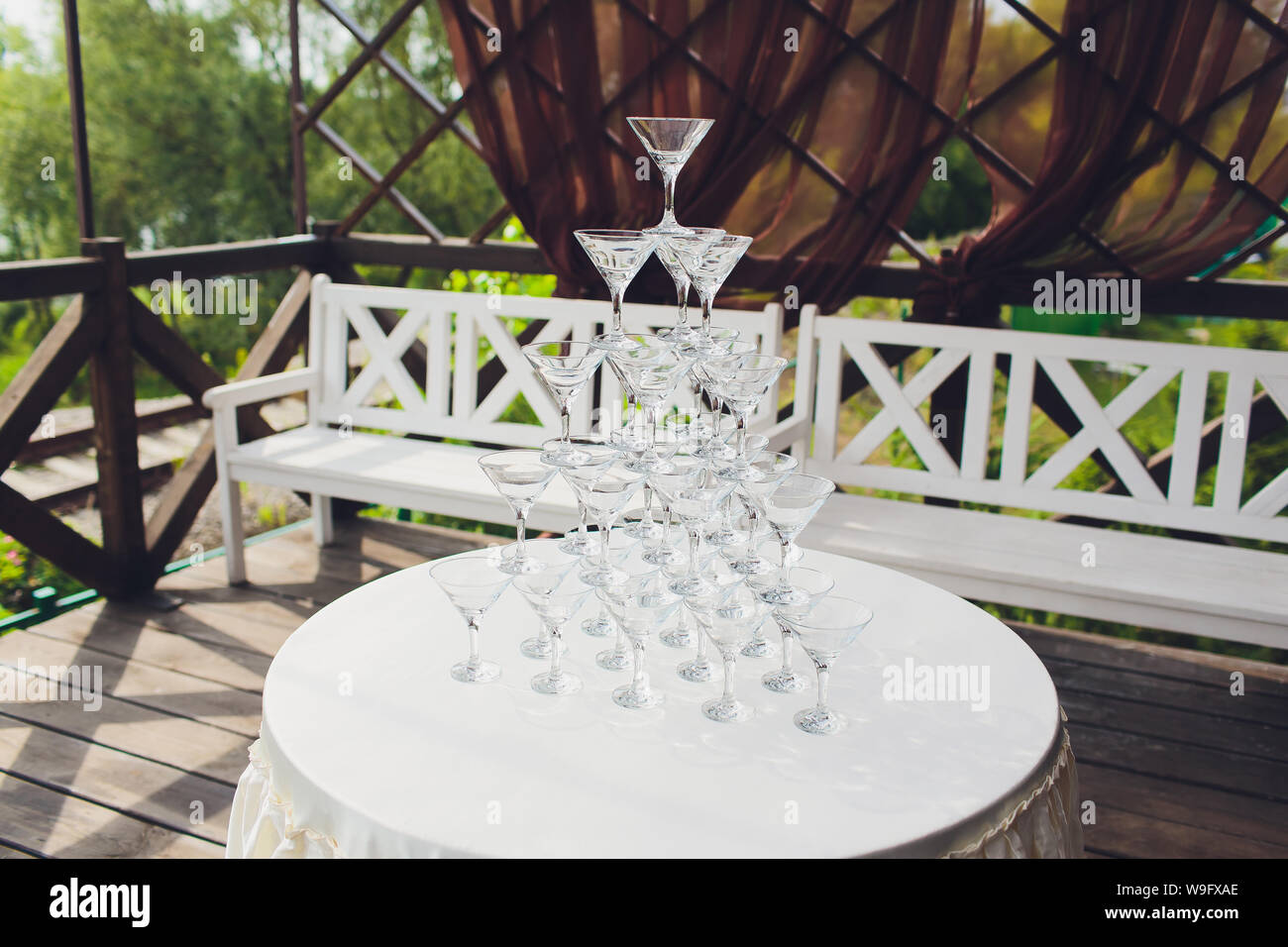 Pyramid of wine glasses with champagne . Champagne is poured into the ...
