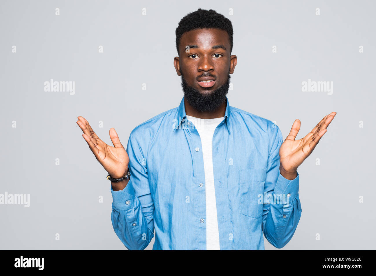 Portrait of young african american man gesturing do not know sign with ...