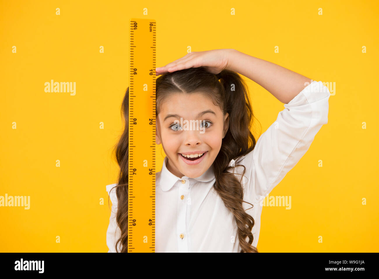 I am still growing. Tall kid. Kid school uniform hold ruler. Pupil cute ...