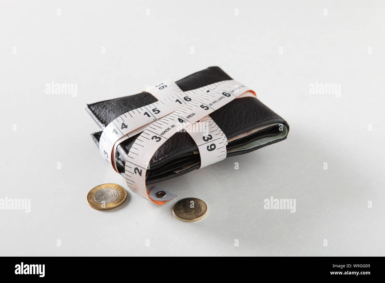 Close up of wallet with tape measure and coins Stock Photo - Alamy