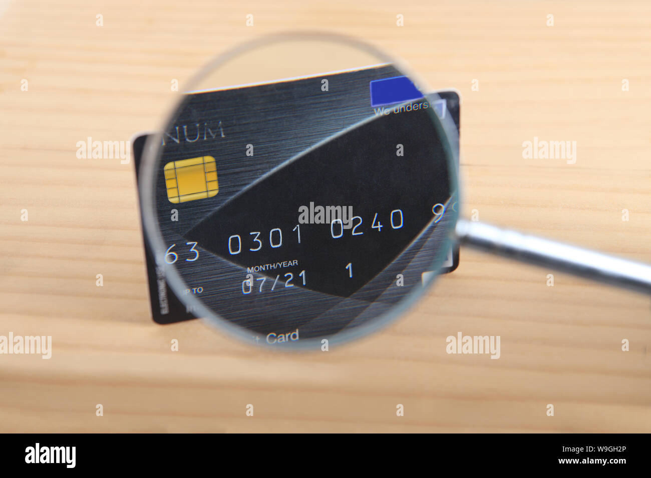 Credit card looks through a magnifying glass Stock Photo - Alamy
