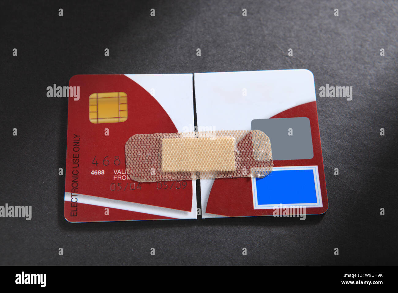 Credit card cut in half with a band-aid holding it together Stock Photo ...