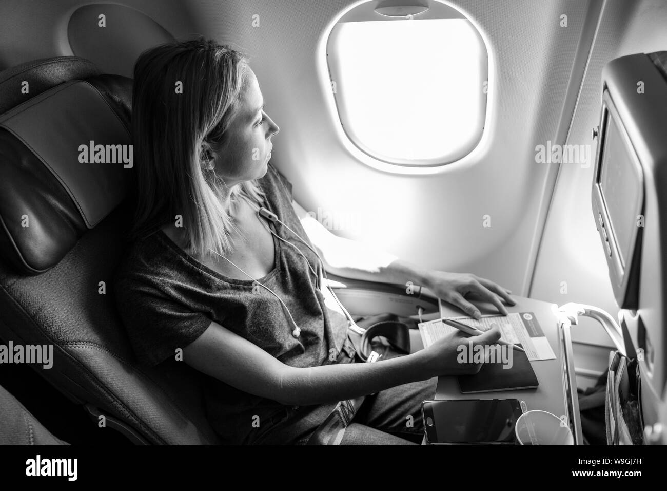 Casual woman flying on commercial passengers airplane, filling in ...