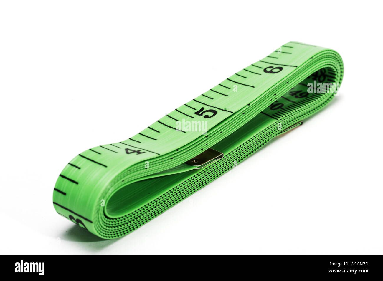 Folded green Measuring tape isolated on white background. Used for ...