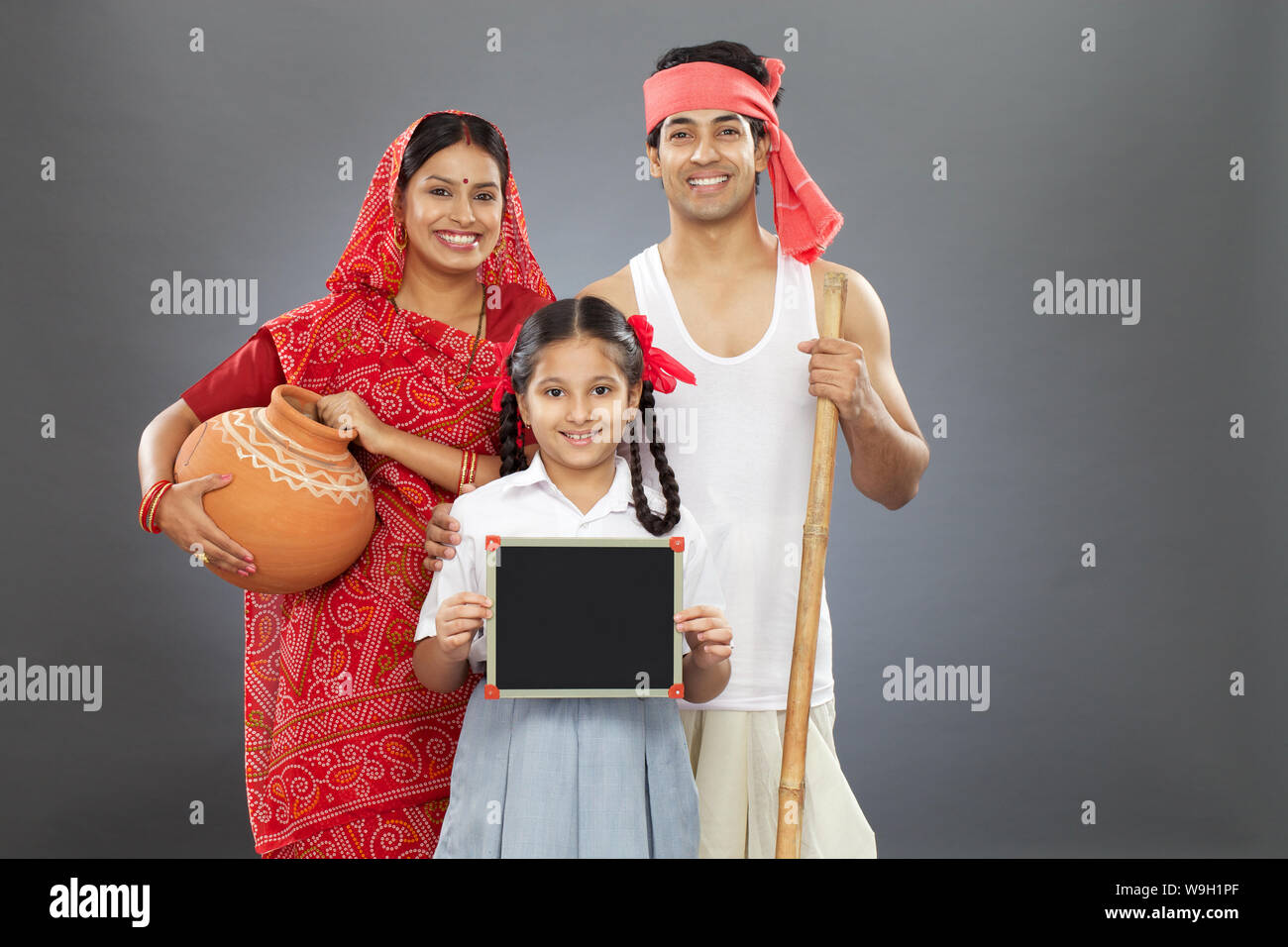 Schoolgirl holding a blank slate standing with her parents Stock Photo ...