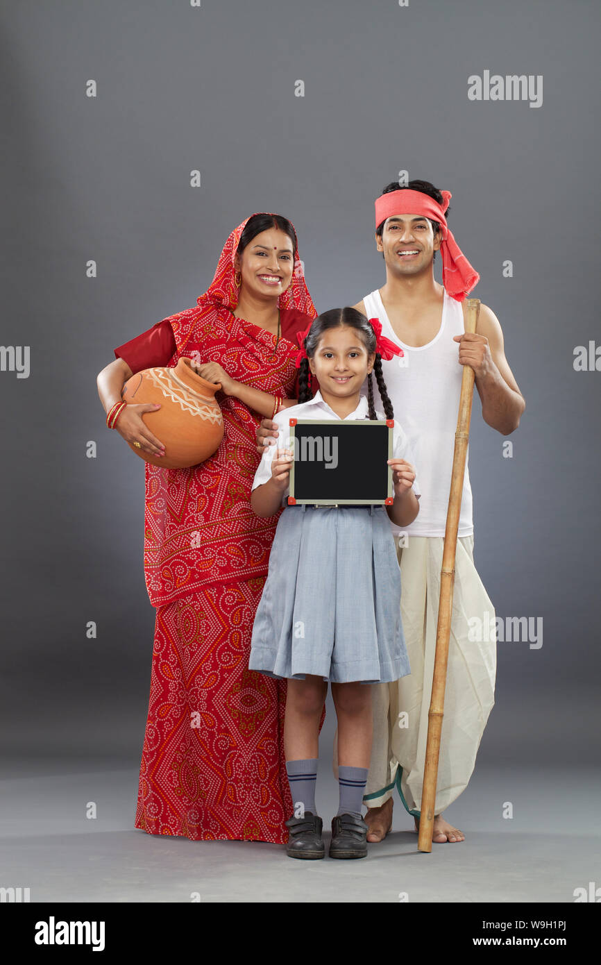 Schoolgirl holding a blank slate standing with her parents Stock Photo ...