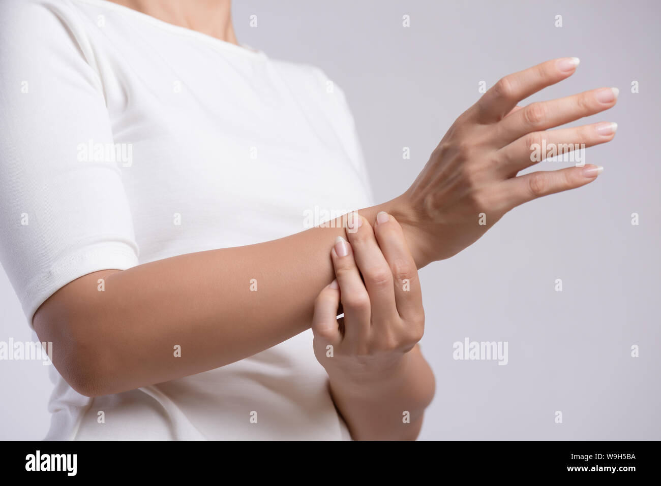 Closeup woman holds her wrist hand injury, feeling pain. Health care ...