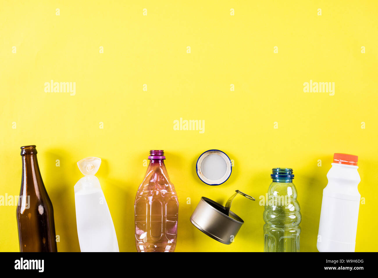 Top view of Different garbage materials for recycling on yellow ...