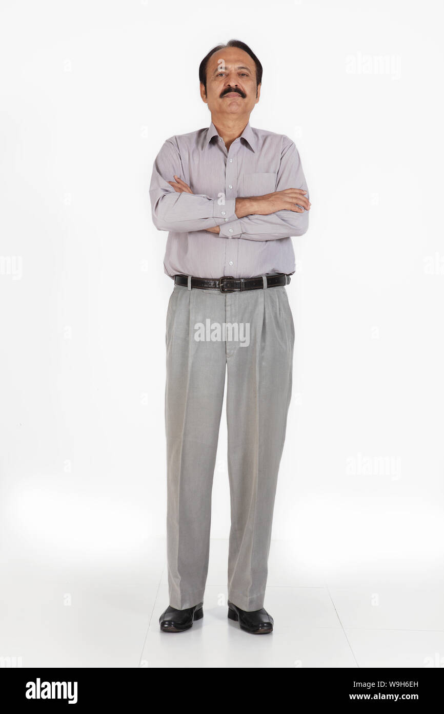 Mature man standing with his arms crossed Stock Photo - Alamy