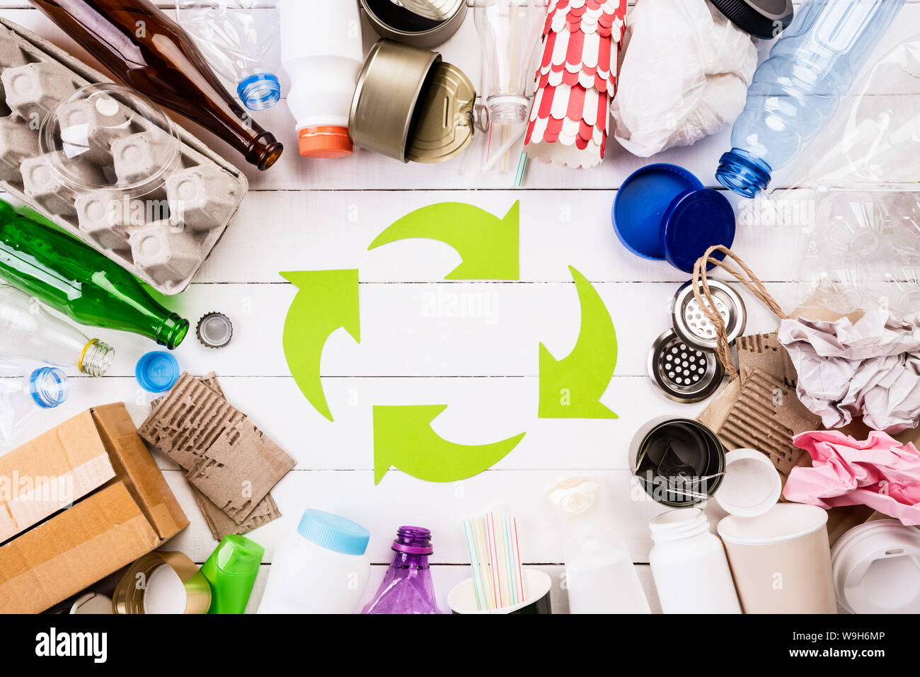 Top view of Different garbage materials with recycling symbol on white ...