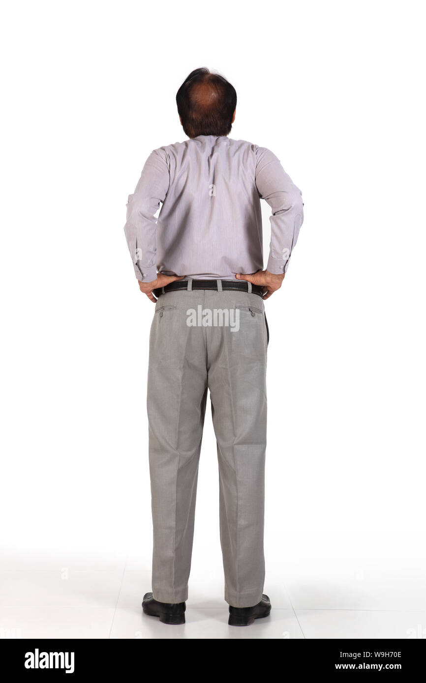Rear view of a man suffering from lower back pain Stock Photo - Alamy