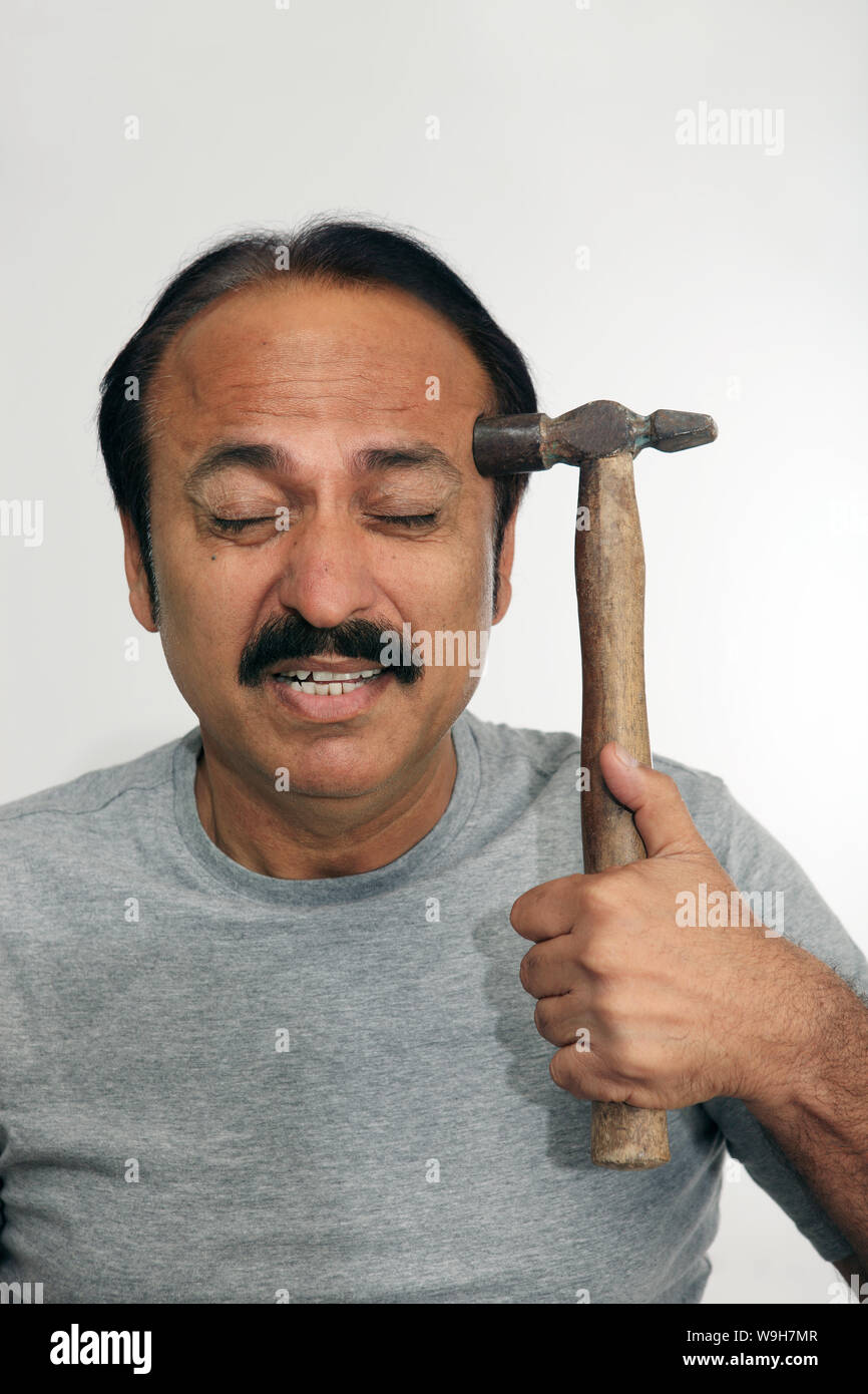 Mature man shattering head with hammer Stock Photo - Alamy