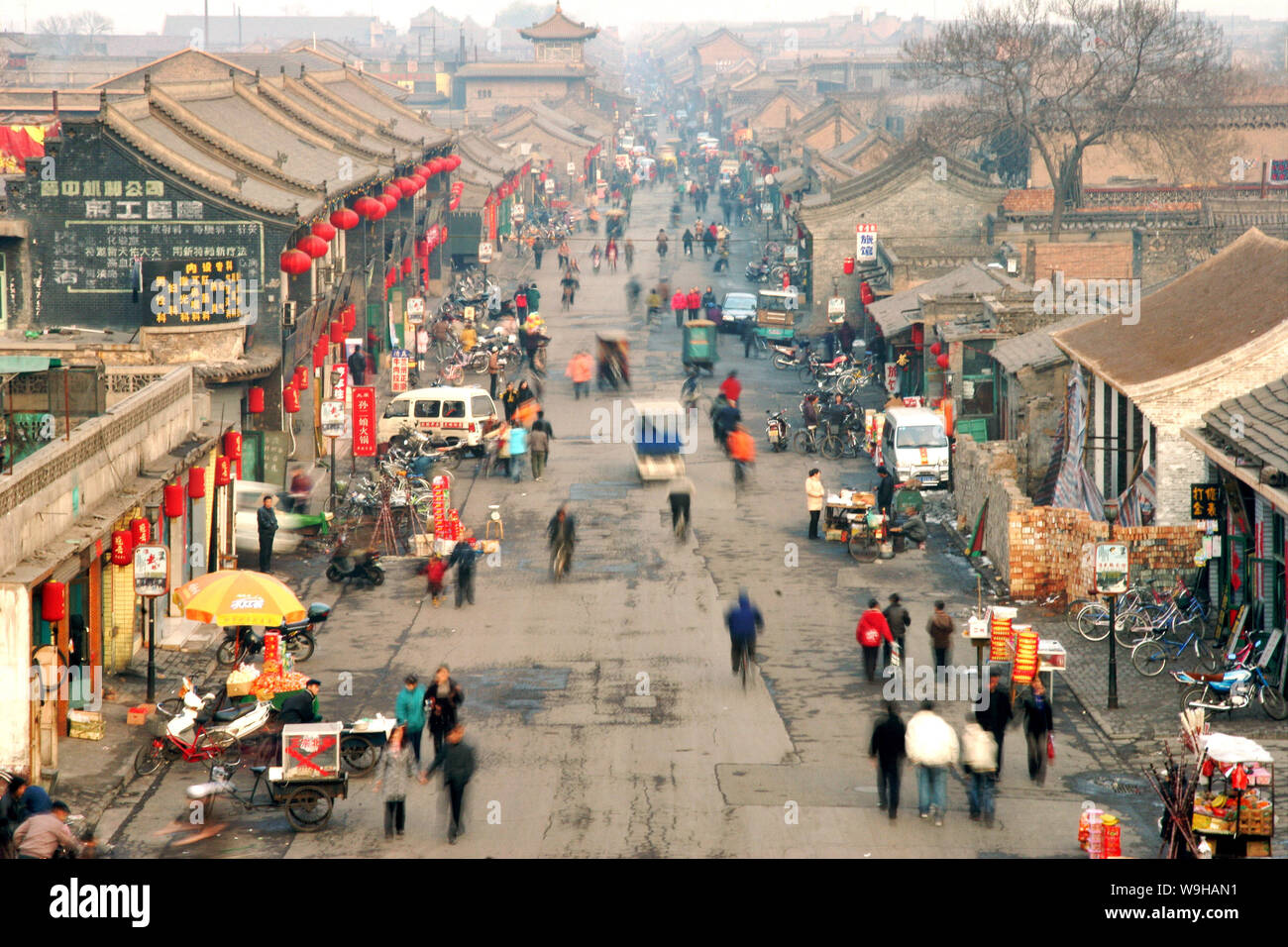 Local residents and tourists are seen on a street in Pingyao old town ...