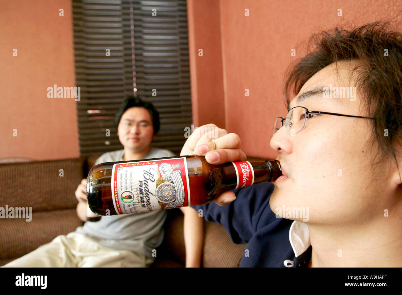 Two Chinese young men drink Budweiser beer in a bar in Shanghai, April ...