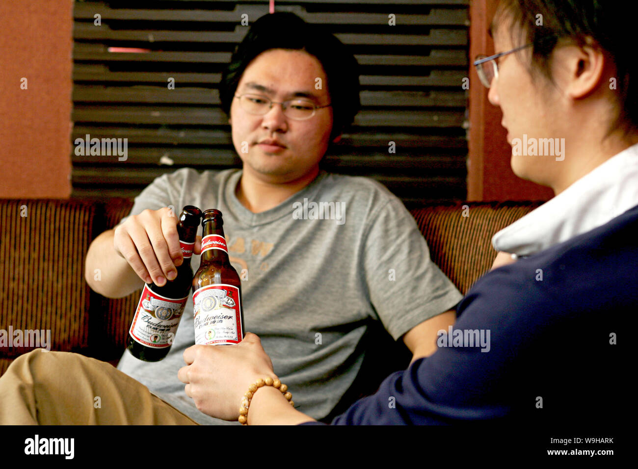 Two Chinese young men drink Budweiser beer in a bar in Shanghai, April ...