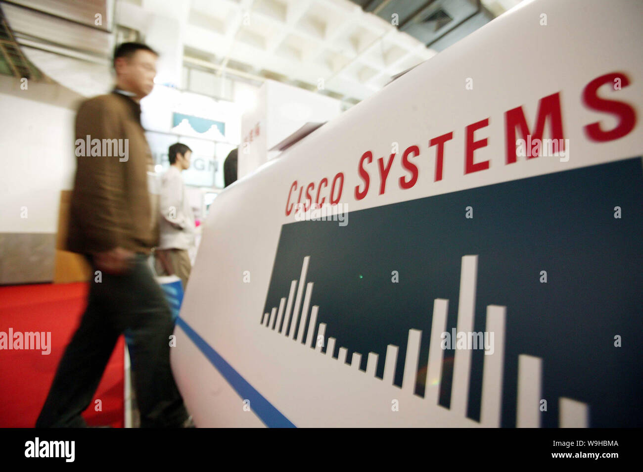 Chinese visitors walk through the stand of Cisco System during an ...
