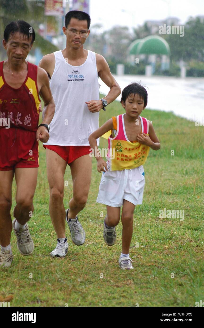 8-year-old Chinese marathon girl Zhang Huimin, right, accompanied by ...