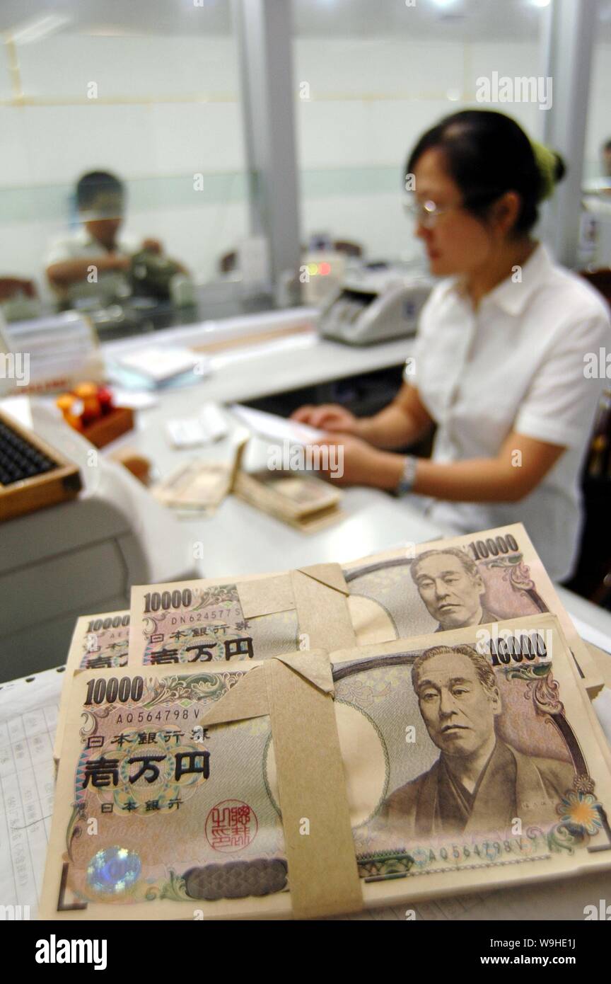 A Chinese bank clerk counts Japanese Yen banknotes at a branch of China ...