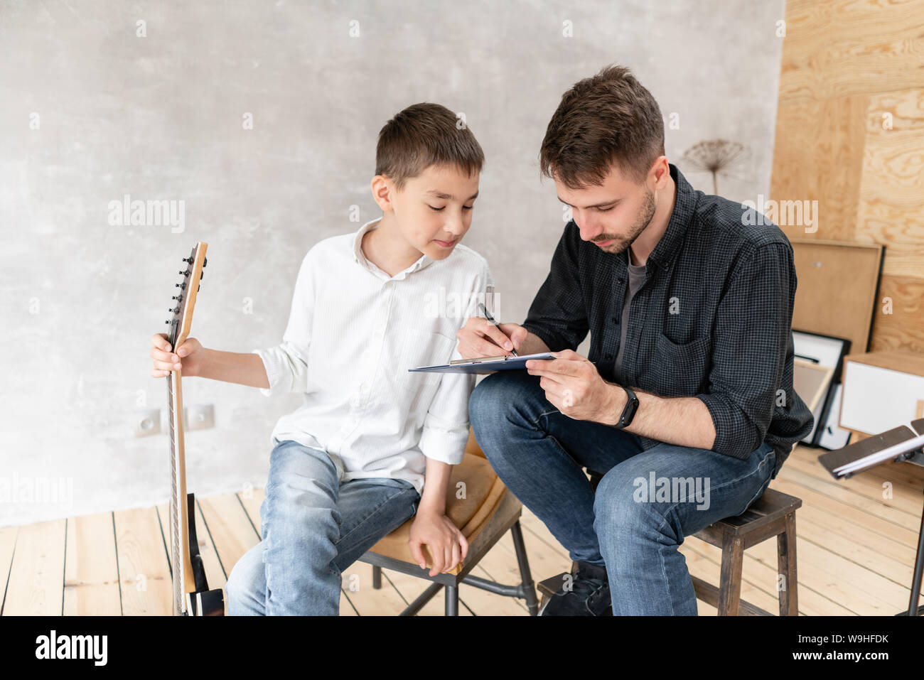 Older brother explains to his younger one how to use notes on music ...