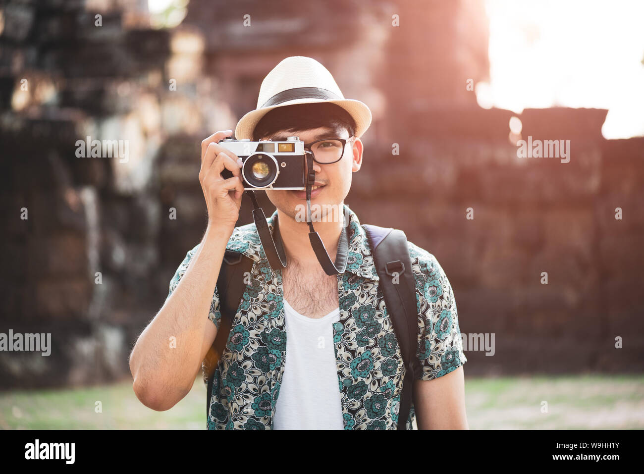 Young Man Photographer Traveler with backpack taking photo with his ...