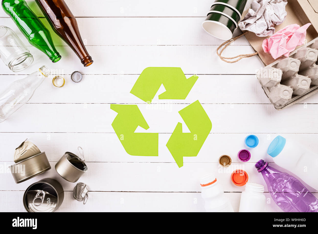 Top view of Different garbage materials with recycling symbol on white ...