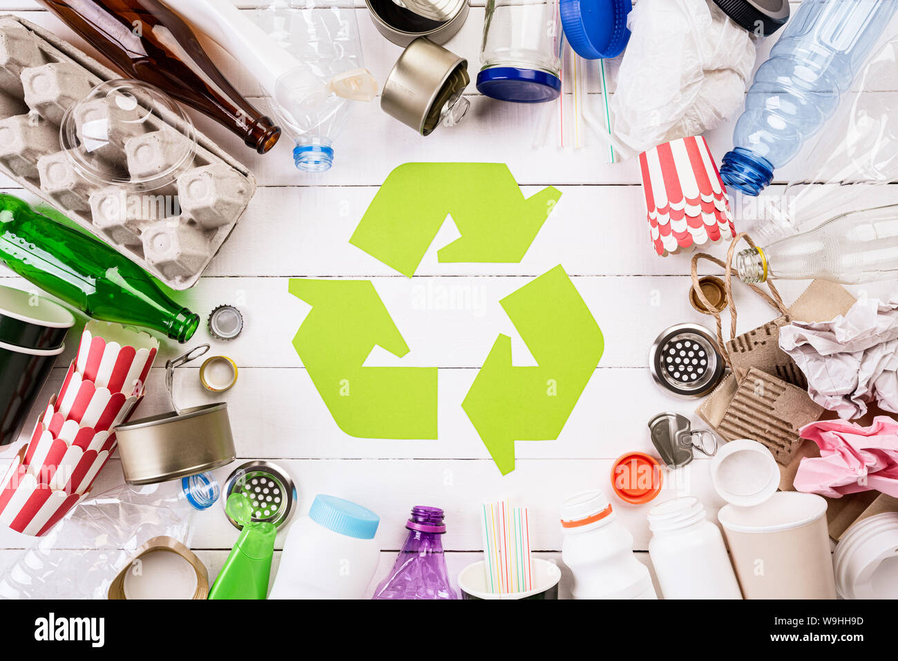 Top view of Different garbage materials with recycling symbol on white ...