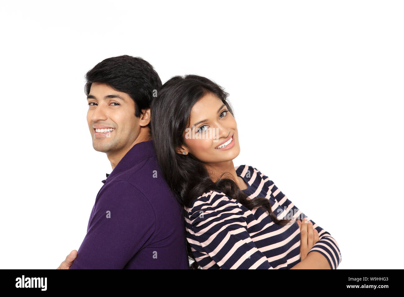 Young couple smiling back to back Stock Photo - Alamy