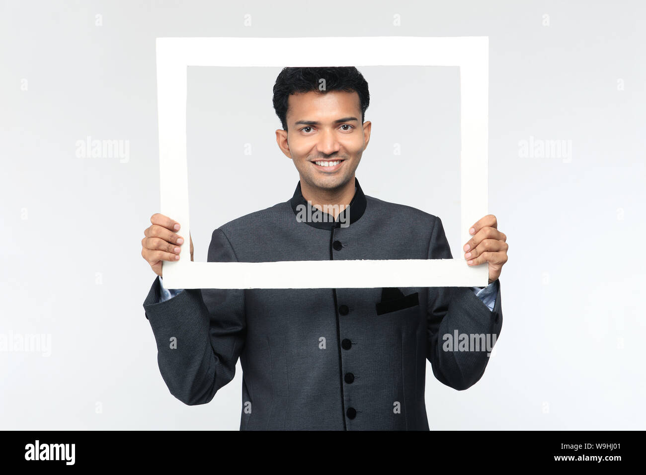 Young man looking through empty frame Stock Photo - Alamy