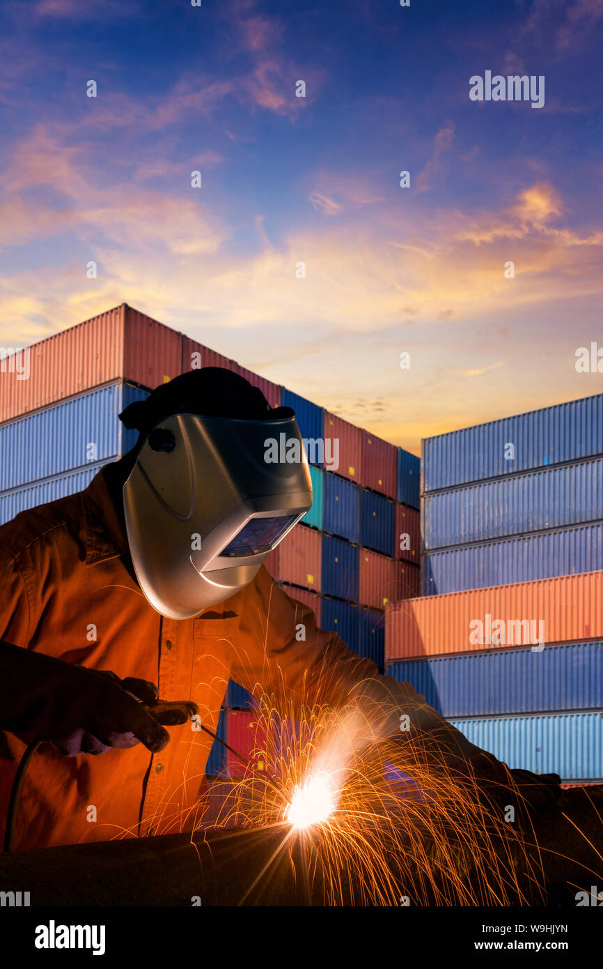 Industrial welding worker welding steel structure with cargo container ...