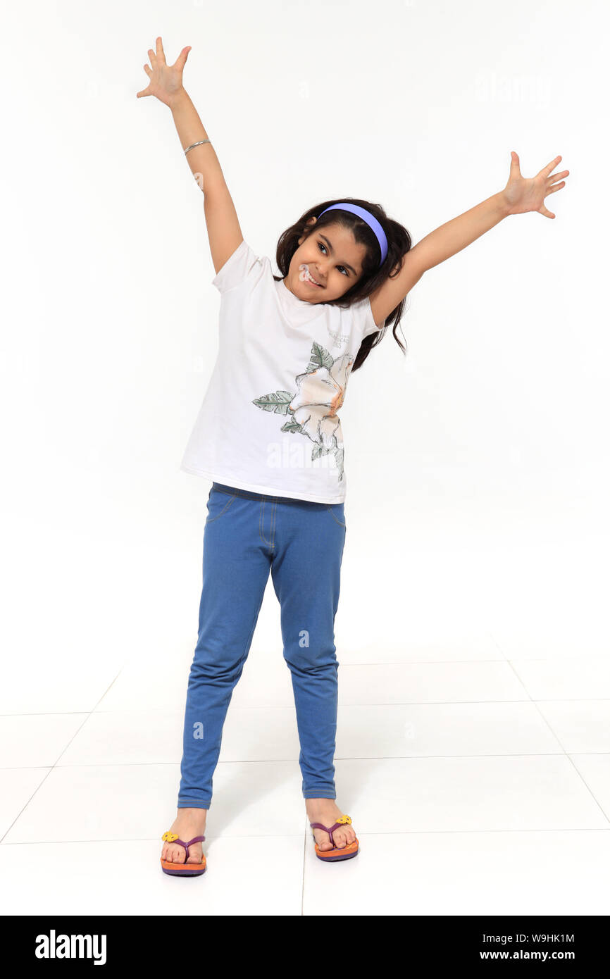 Girl standing with her arms raised Stock Photo - Alamy