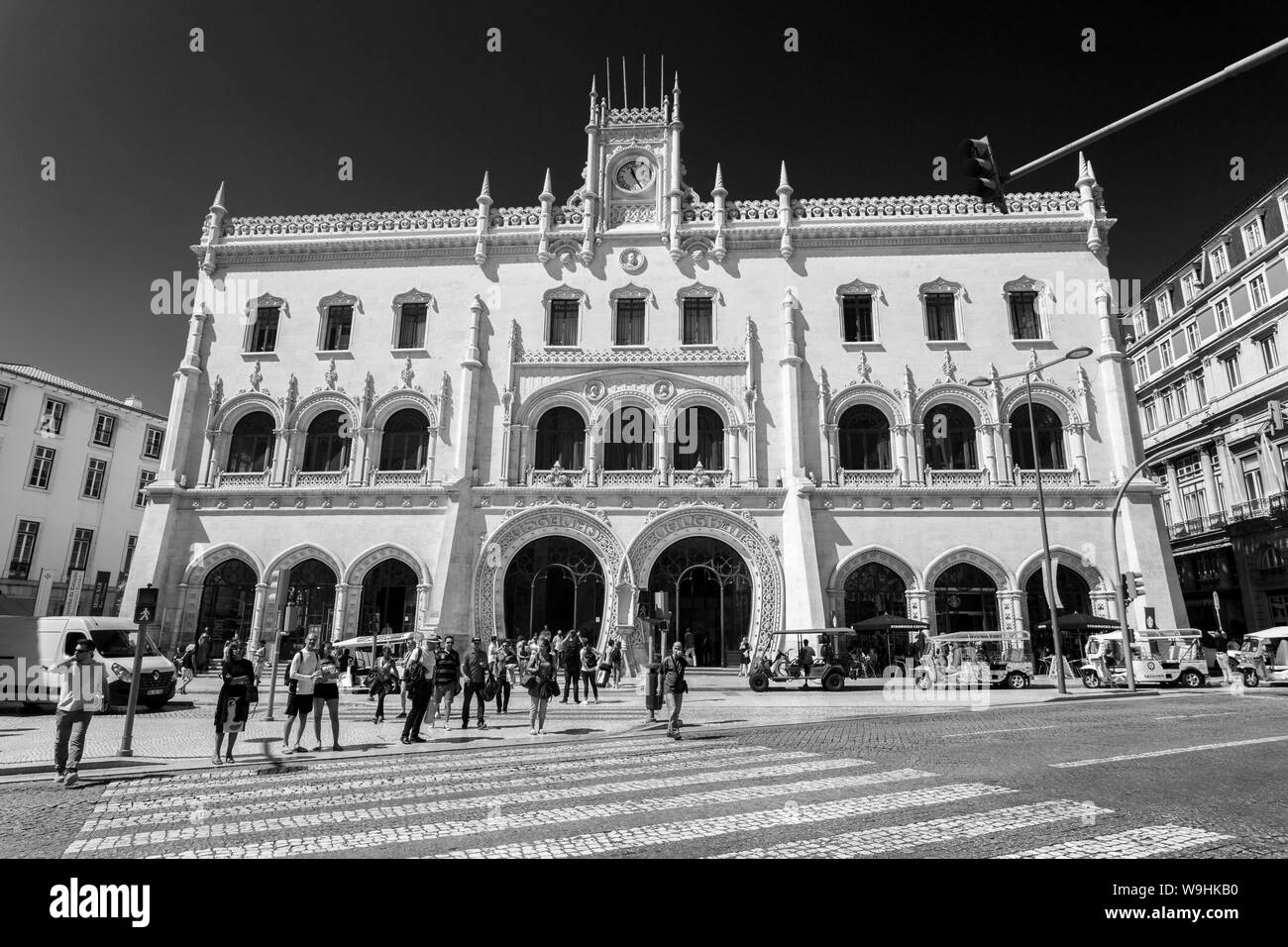 People in front of the Neo-Manueline style facade of Rossio railway ...