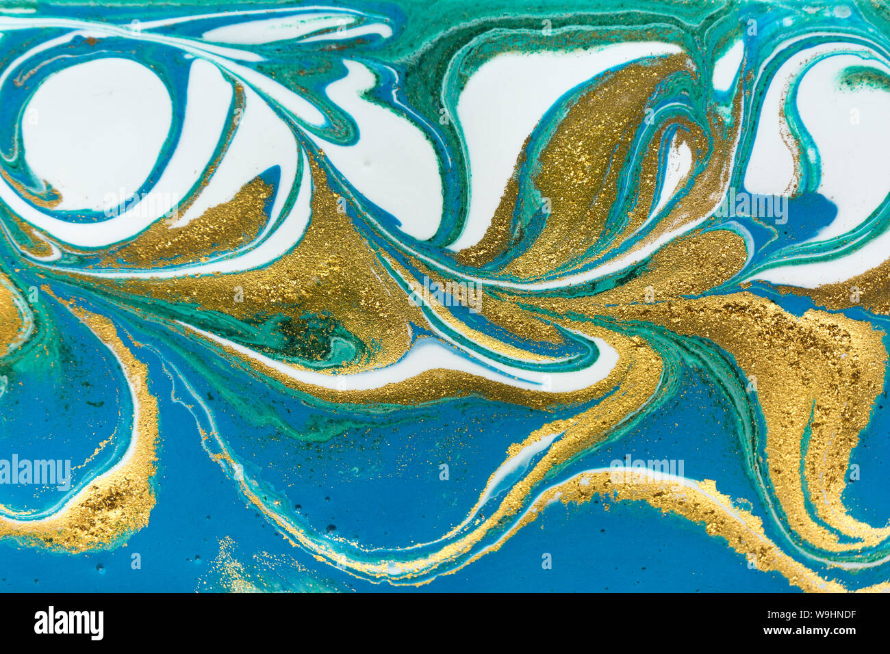 Liquid uneven blue and green marbling pattern with golden glitter and ...