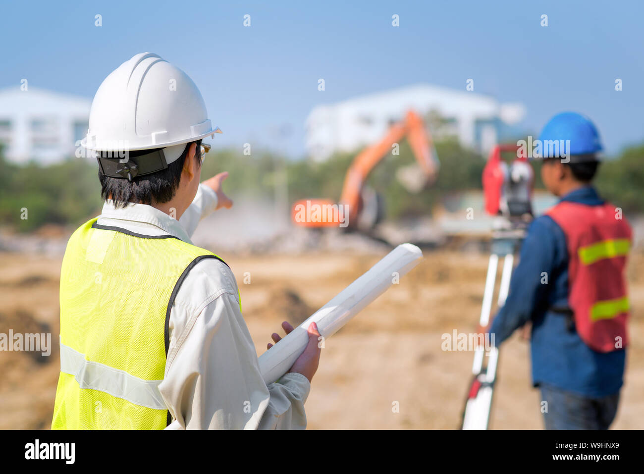 Construction engineer hodling construction drawing with foreman worker ...