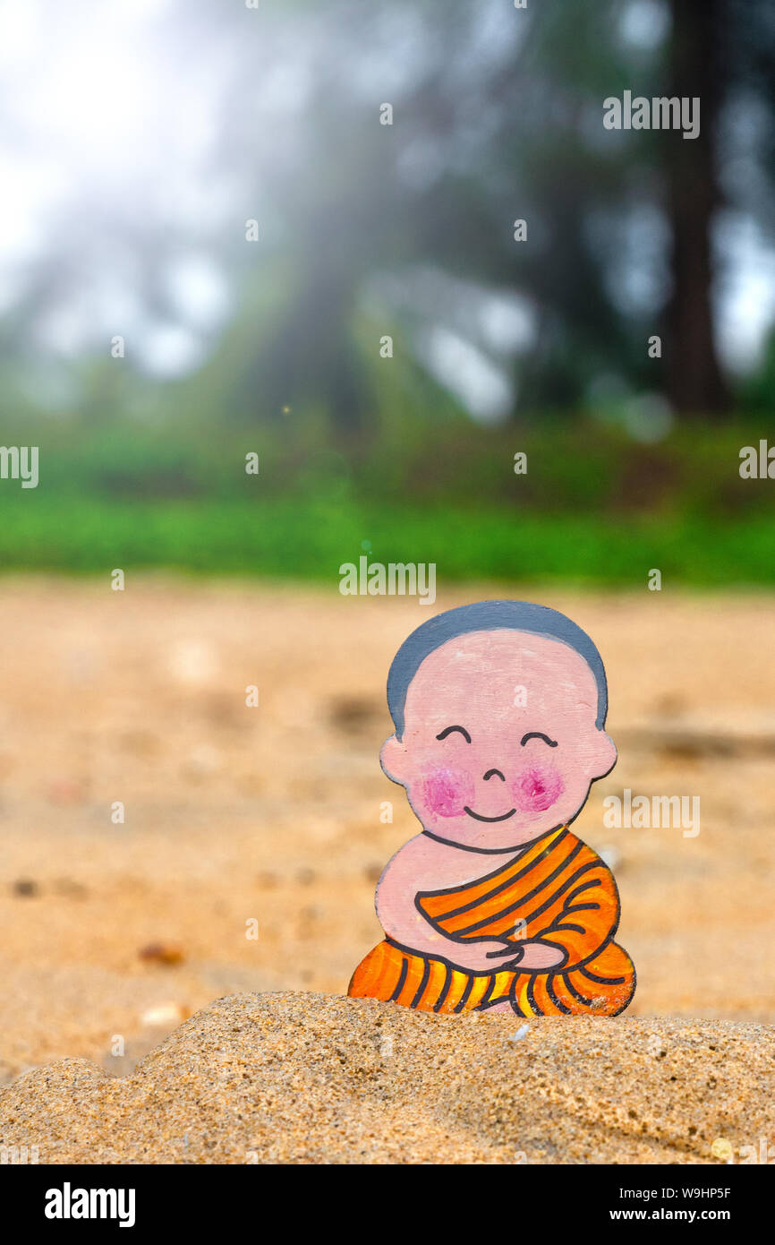 Little boy Buddhist, little Buddha, sitting on the sand against the ...