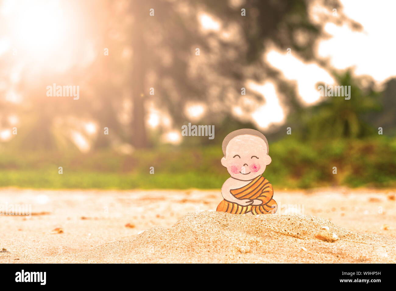Little boy Buddhist, little Buddha, sitting on the sand against the ...