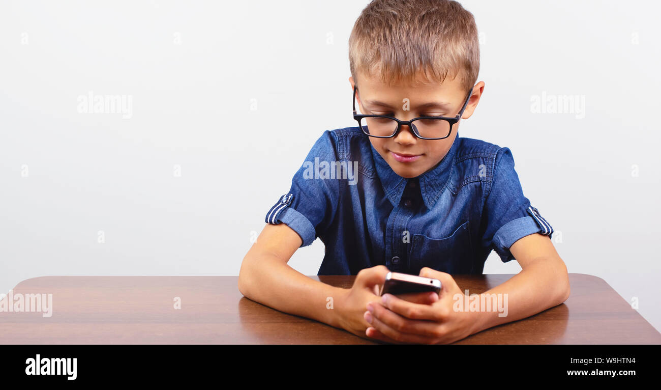 Banner Portrait of smiling boy with glasses using mobile phone on ...