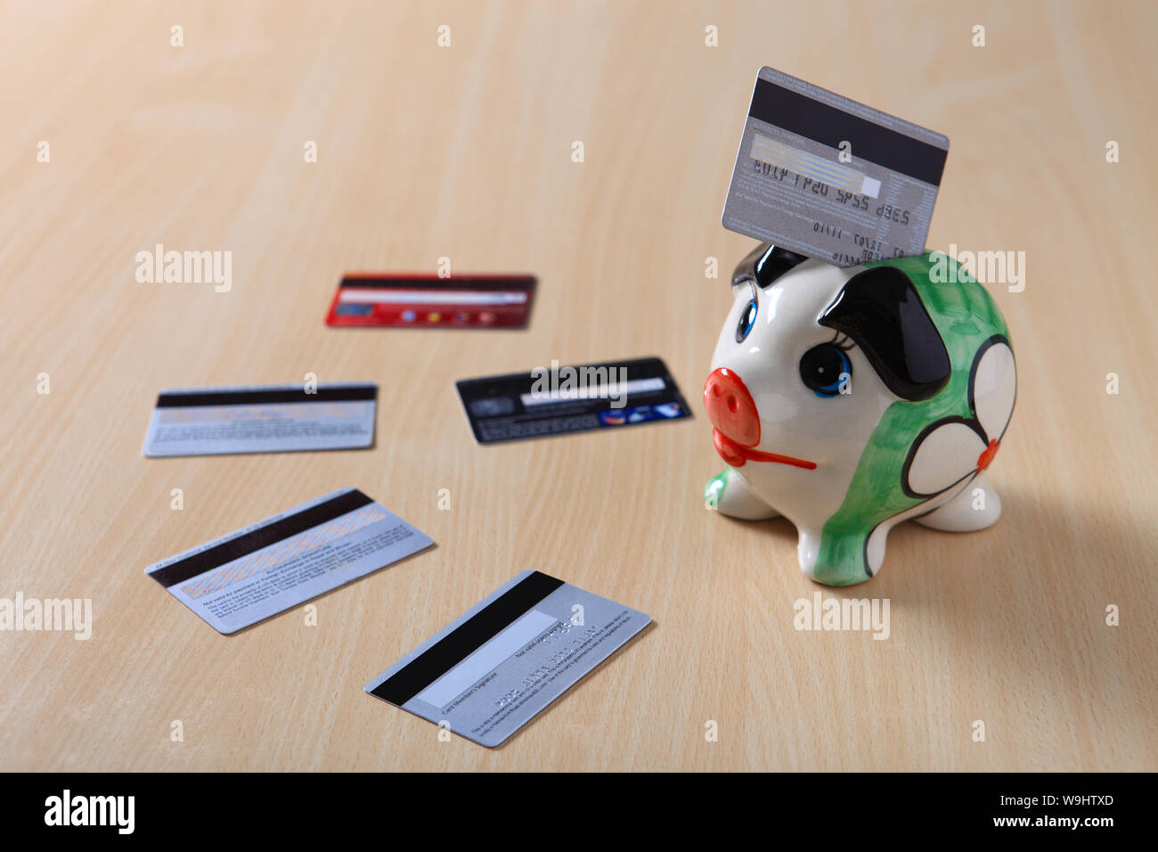 Credit card inserting into a piggy bank Stock Photo - Alamy