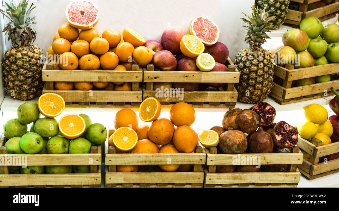 Boxes with different kinds of fresh fruits displayed in wooden crates ...
