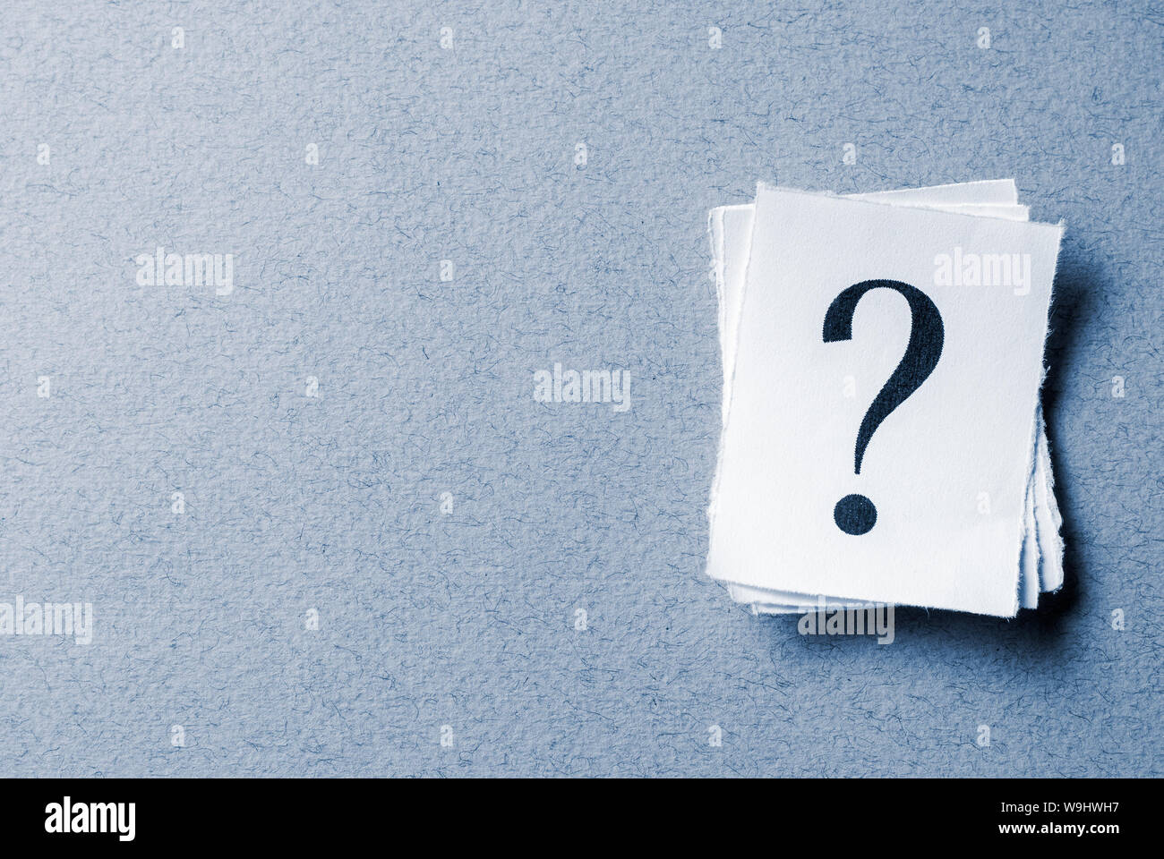 Single curled card with printed question mark placed to the side on a ...