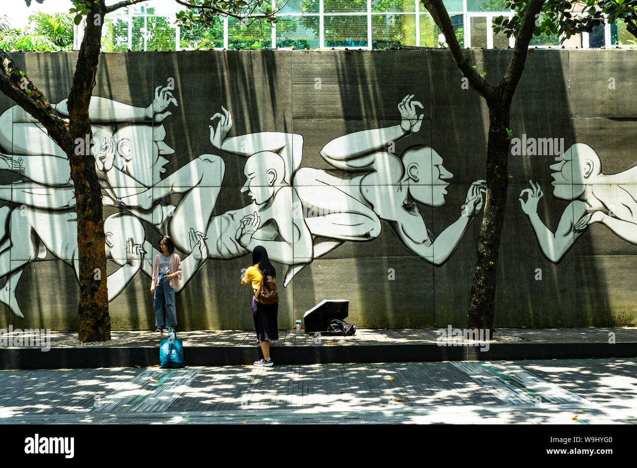 Visitors at OCT LOFT mural background in Shenzhen China Stock Photo - Alamy