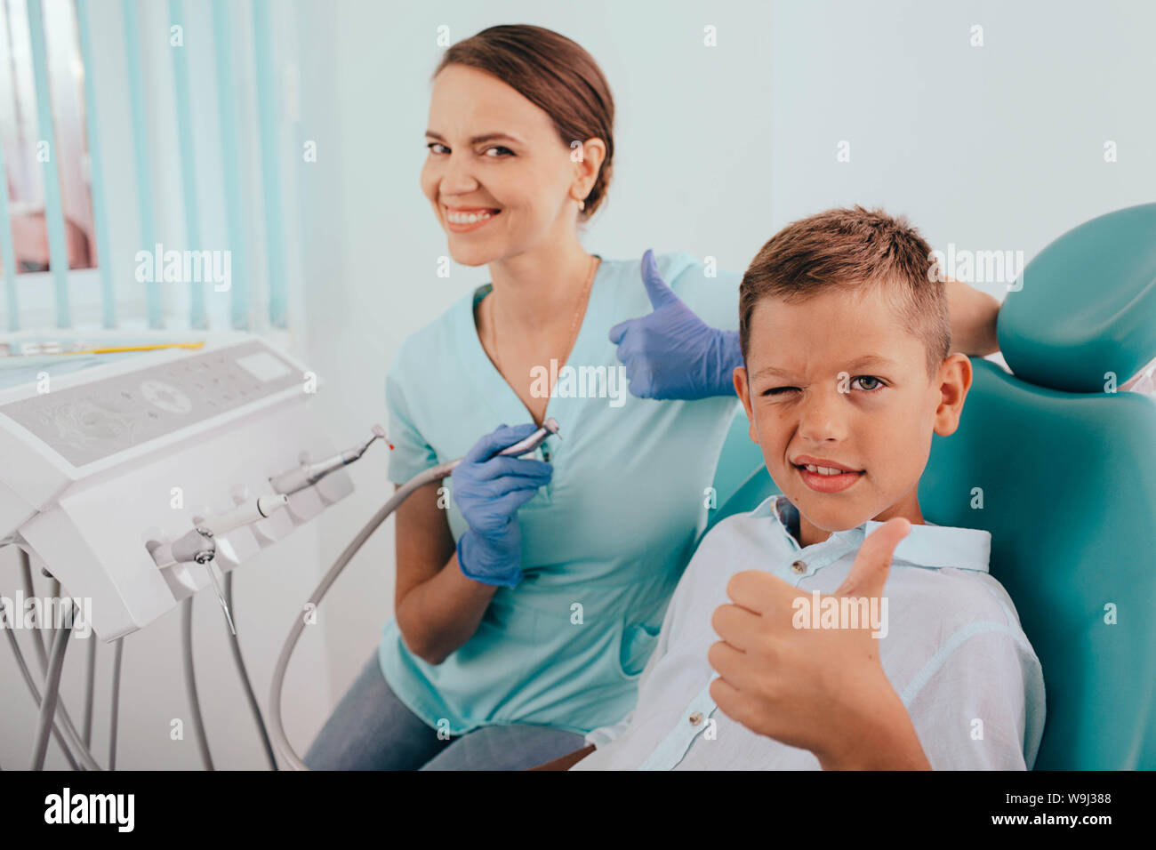 Cute boy smiling while teeth exam . Happy boy sitting in dentists chair ...