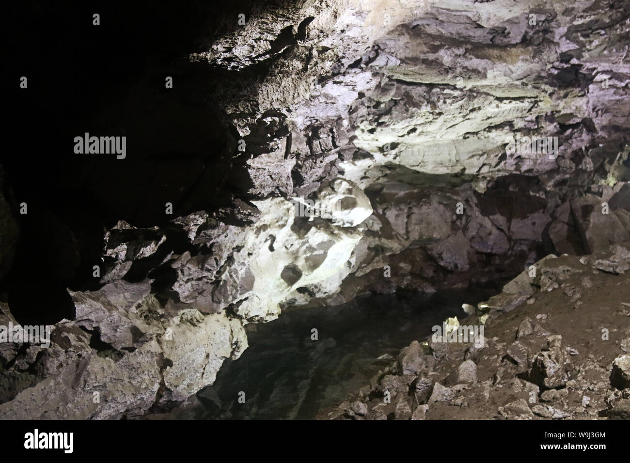 Half-filled with rock and clay natural cave. After collapse of ...