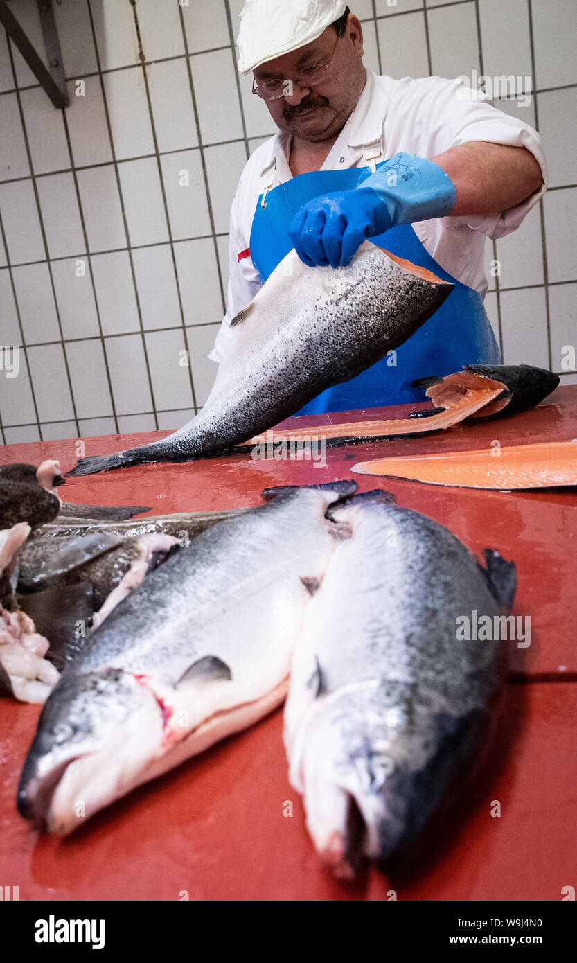 Hamburg, Germany. 14th Aug, 2019. An employee fillets salmon at a ...