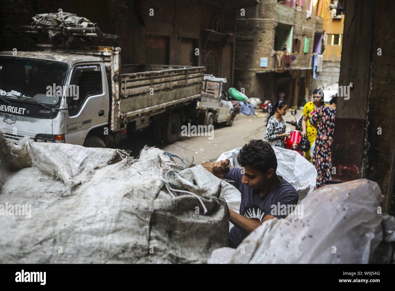 Il Cairo, Egypt. 14th July, 2019. A man sorts rubbish to be transported ...