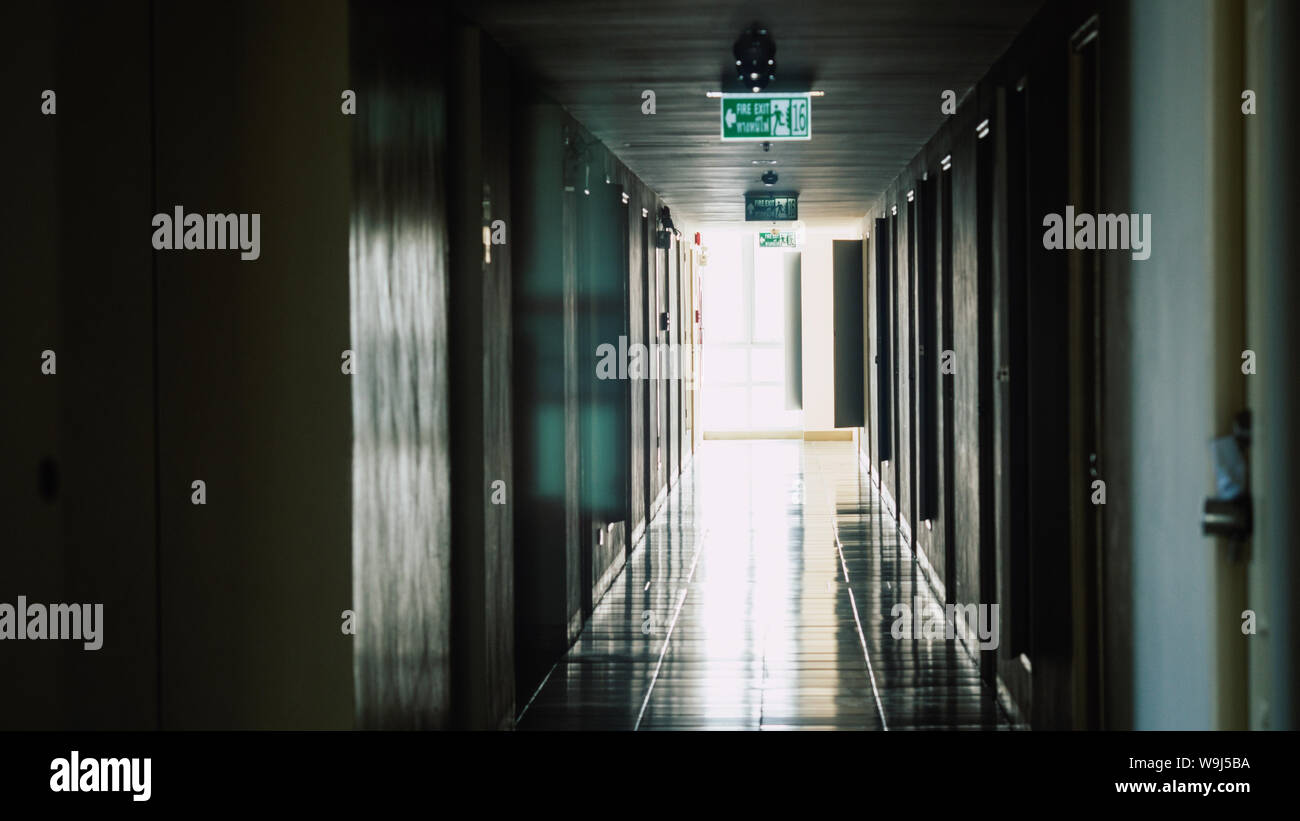 Walkway to the fire escape door, Fire exit sign over corridor walkway ...