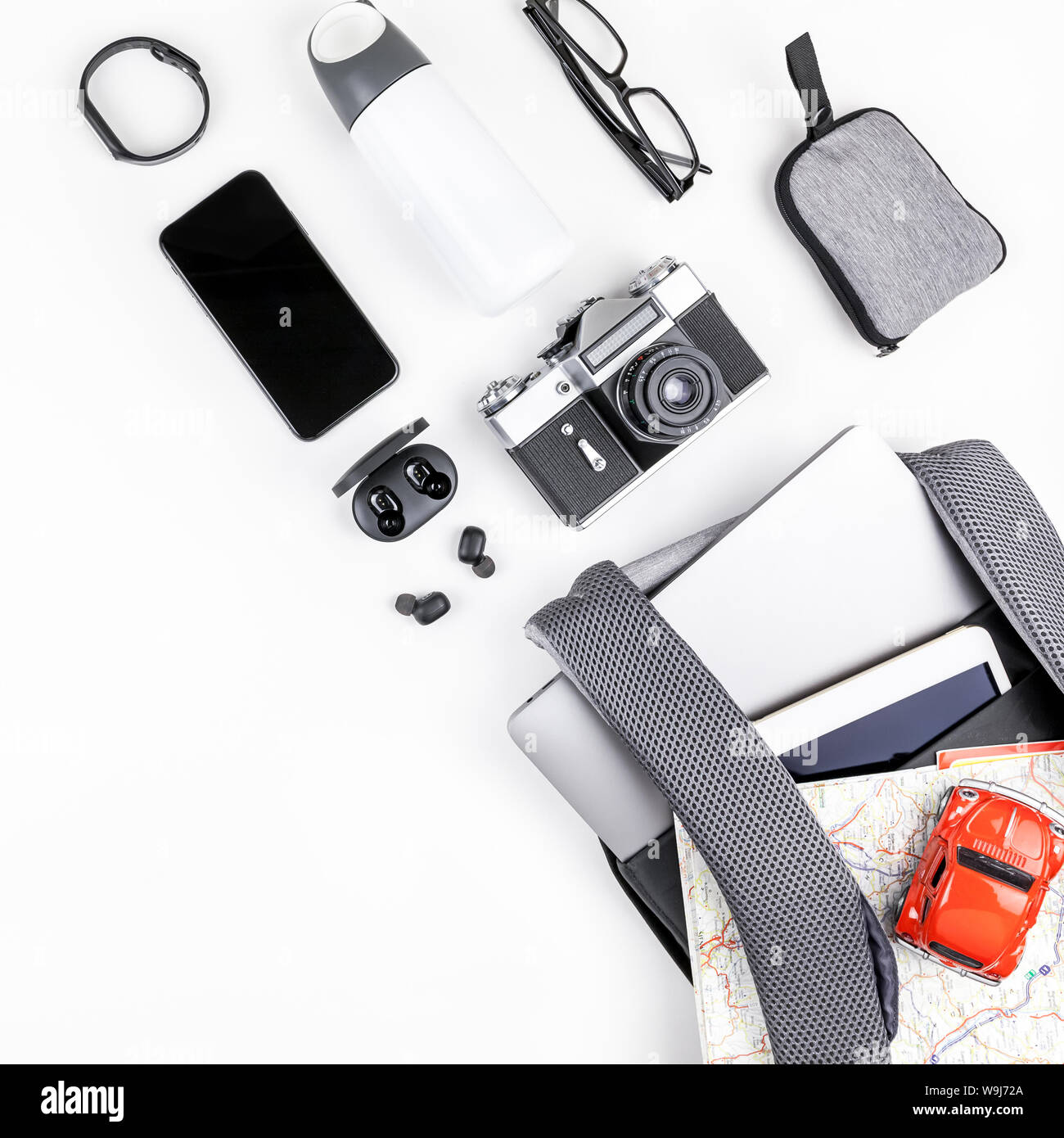 Creative top view flat lay of open backpack with laptop and tablet ...