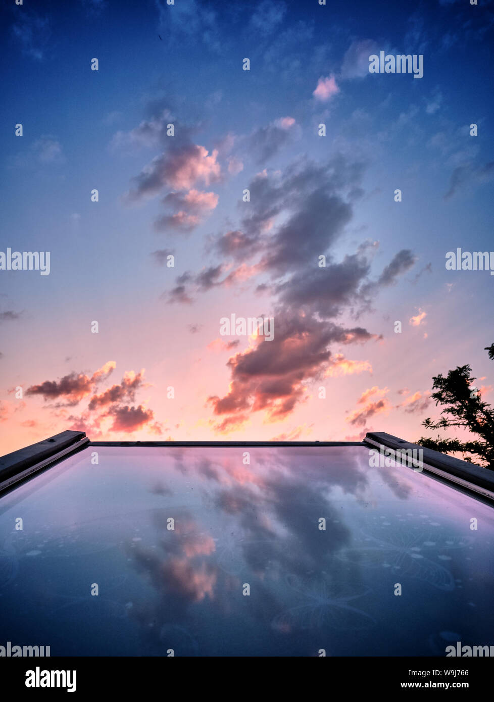 View out of a roof window into the blue sky with a beautiful summer ...
