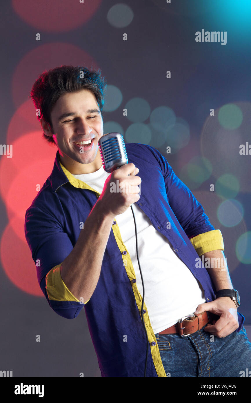 Man singing into microphone and smiling Stock Photo - Alamy